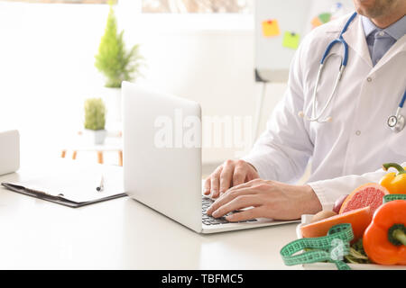 Male nutritionist working in his office Stock Photo - Alamy