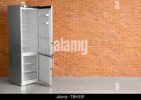 Open empty fridge near brick wall Stock Photo - Alamy