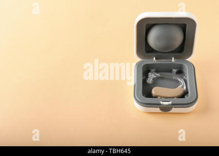 Box with hearing aid on color background Stock Photo - Alamy
