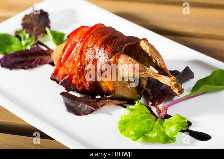 Image of baked in bacon quail with balsamic sauce on the plate Stock ...