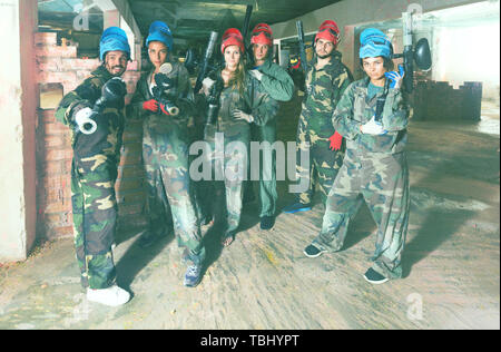 Portrait of red and blue teams who are ready for paintball playing ...