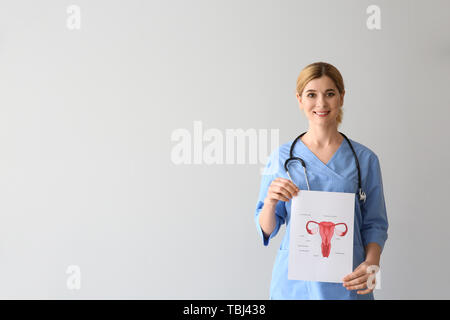 Portrait of beautiful gynecologist on light background Stock Photo - Alamy