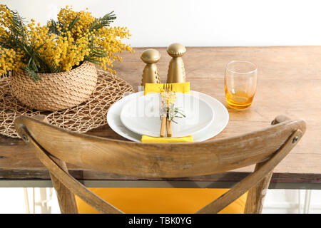 Beautiful table setting with mimosa flowers and candles in room Stock ...