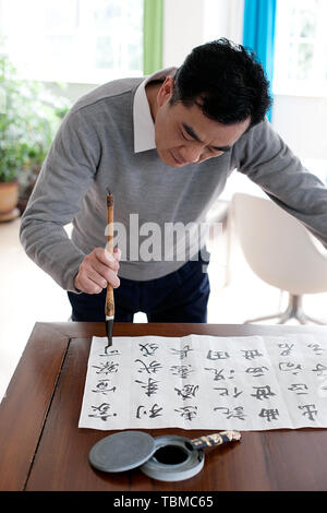 An elderly man practicing calligraphy Stock Photo - Alamy