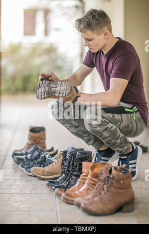 The man is polishing the shoes on the terrace during the spring time ...