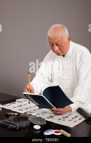 An old man practicing calligraphy Stock Photo - Alamy