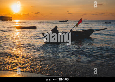 Wooden fishery boat floting on the sea with sunset time low lighting ...