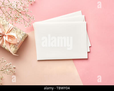 Envelopes with blank card and flowers on color background Stock Photo ...