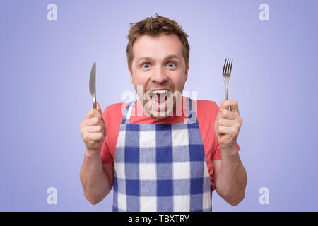 Hungry cook in apron hold tomato and knife for cooking healthy ...