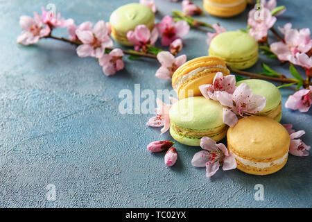 Beautiful blooming branches and tasty macarons on grey background Stock ...