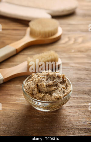 Brushes and body scrub on wooden background Stock Photo - Alamy