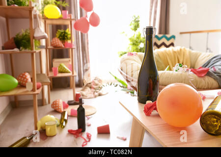 Terrible mess after party. Trash, bottles, food, cups and clothes on ...
