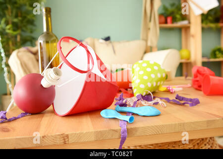 Terrible mess after party. Trash, bottles, food, cups and clothes on ...