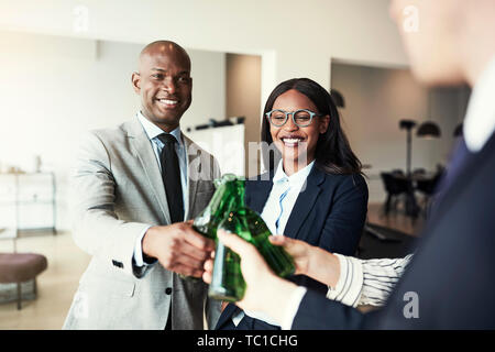 Business team celebrating with beers and toasting in the office ...