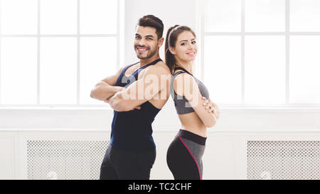 Fitness Couple Standing Strong In The Gym And Flexing Muscles ...