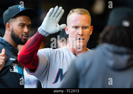 Miami Marlins' Garrett Cooper, left, high-fives before a baseball game ...