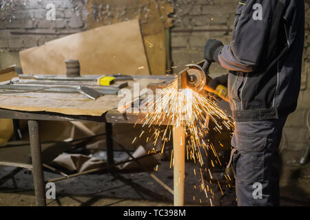 Blacksmith sawing metal with hand circular saw Stock Photo - Alamy