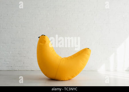 yellow bean bag chair near white brick wall in modern home Stock Photo ...