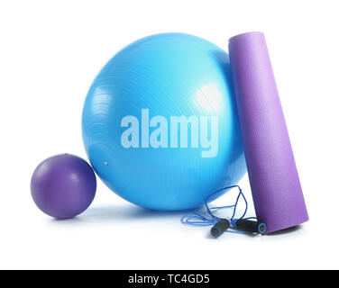 Set of sports equipment with fitness ball on floor near color wall ...