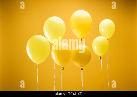 festive minimalistic decorative balloons on yellow background with copy ...