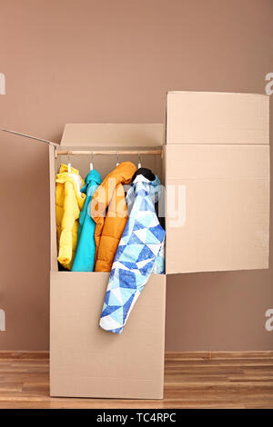 Wardrobe box with clothes near color wall Stock Photo - Alamy