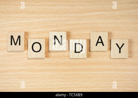 The word Monday, spelt out using wooden tiles on a wood effect ...