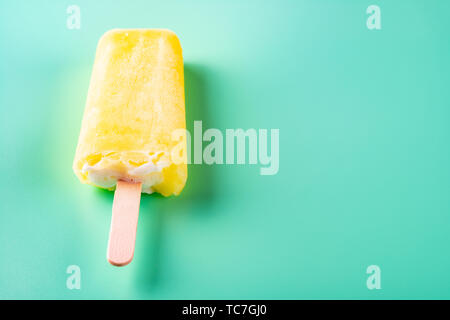 yellow popsicle on a light green background Stock Photo - Alamy