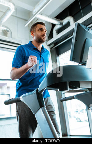 Handsome man running on the treadmill in modern gym Stock Photo - Alamy