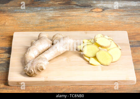 Ginger and cut ginger slices on table Stock Photo - Alamy