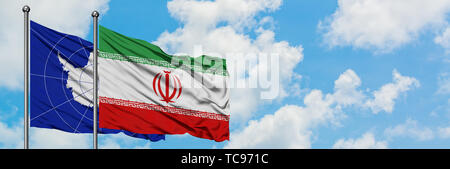 Iran and Antarctica flag waving in the wind against white cloudy blue ...