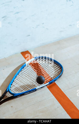 squash racket and ball on the wooden floor. Racquetball equipment on ...