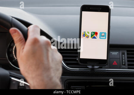 Driving and using waze maps application on smartphone on car dashboard ...