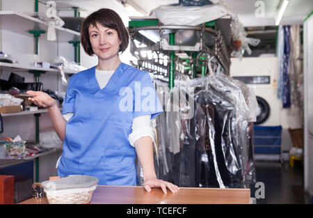 Worker welcoming to dry cleaning salon Stock Photo - Alamy