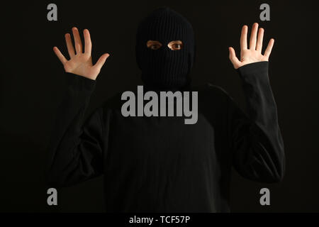 Surrounded and trapped bandit in black mask isolated on black Stock ...