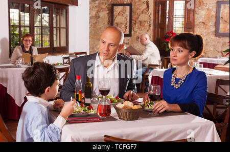 Happy family having dinner and nice talking at restaurant Stock Photo ...