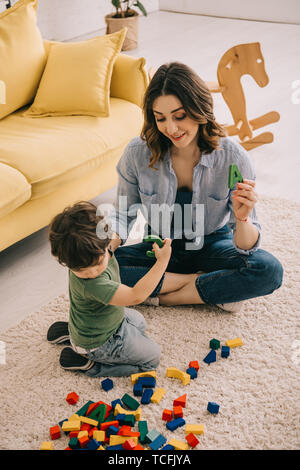Beautiful toddler playing with wooden building blocks on the table at ...