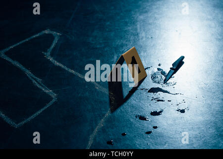Crime scene with chalk outline, knife and blood marks on floor ...