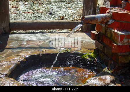 Natural spring folded of old bricks and metallic pipe. Clean fresh ...