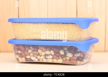 Filled plastic containers on wooden background Stock Photo - Alamy