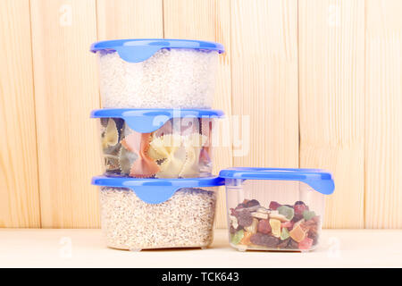 Filled plastic containers on wooden background Stock Photo - Alamy