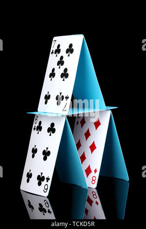Card house isolated on black Stock Photo - Alamy