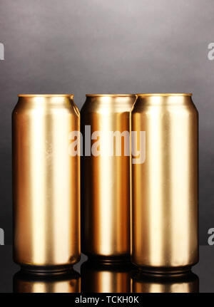 golden cans on grey background Stock Photo - Alamy