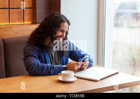 bearded hispanic freelancer using smartphone and eating chinese noodles ...