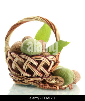 Wicker basket full of walnuts. green and ripe walnuts, knife on wooden ...