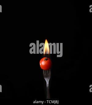 Tomato on fire with blue flames isolated on black background Stock ...