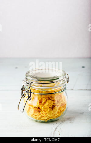 Corn flakes in a glass jar on wooden surface Stock Photo - Alamy