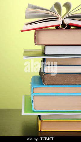 Stack of interesting books and magazines on wooden table on green ...