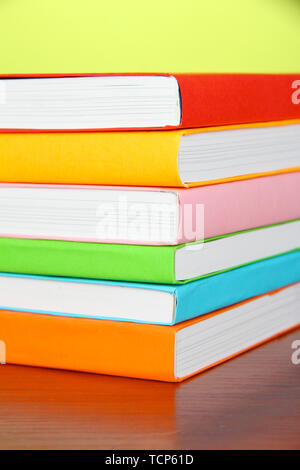 Stack of multicolor books on green background Stock Photo - Alamy
