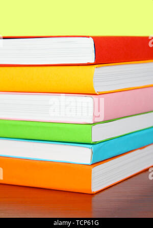 Stack of multicolor books on green background Stock Photo - Alamy