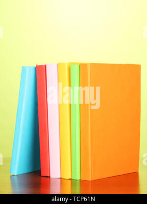 Stack of multicolor books on green background Stock Photo - Alamy